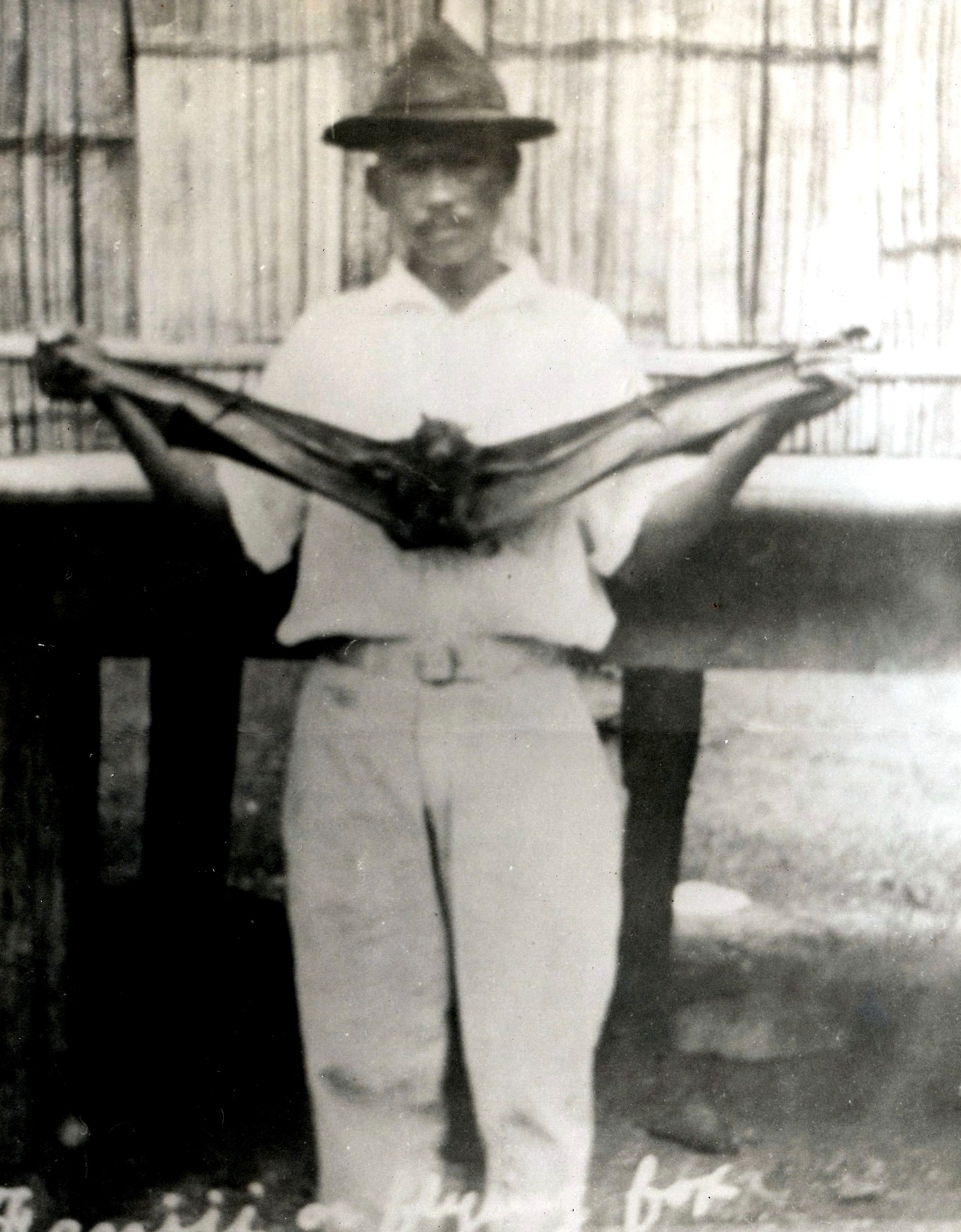 A prewar image of a CHamoru peskådot posing with a fruit bat